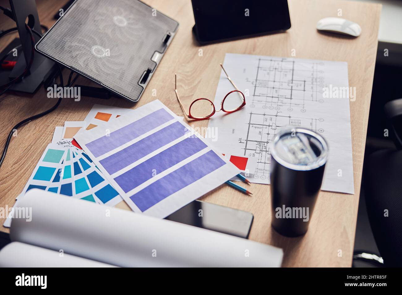 Close up shot of glasses, architectural blueprint with papers and color ...