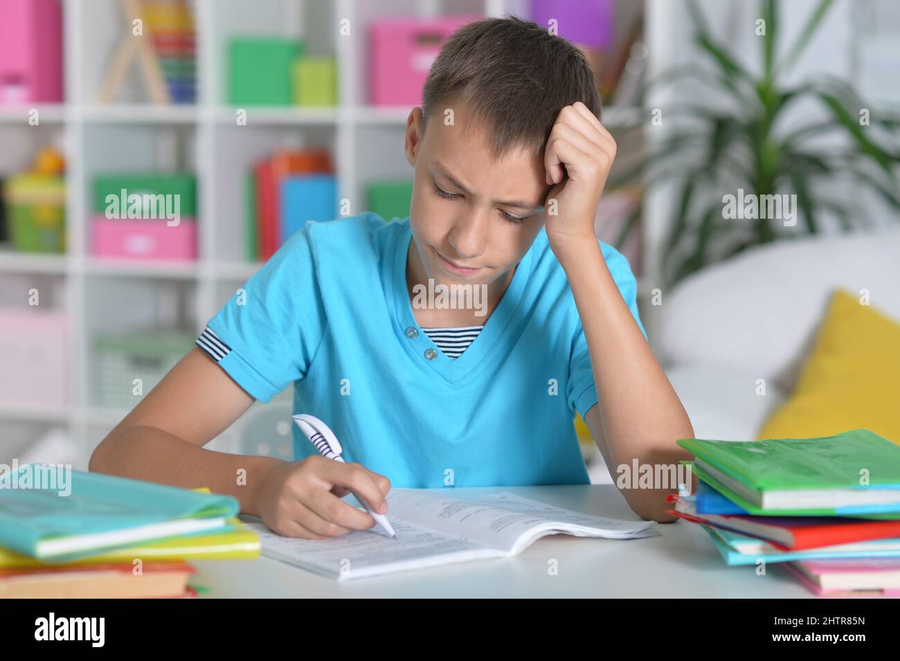 Portrait of tired boy doing homework at home Stock Photo - Alamy