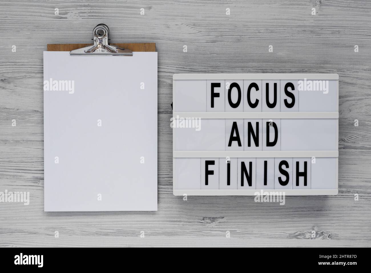 'Focus and Finish' on a lightbox, clipboard with blank sheet of paper ...