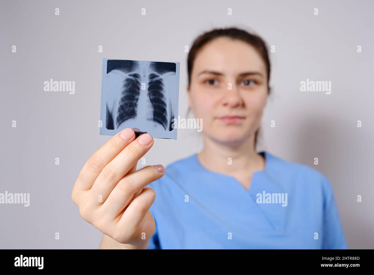 A doctor in a blue uniform shows a picture of a fluorogram of ...