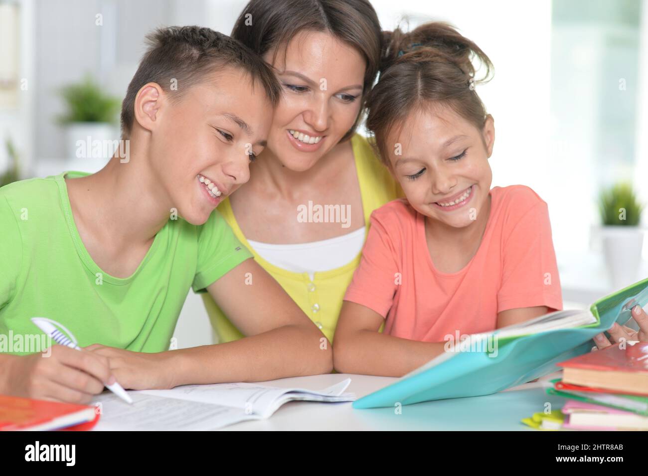 Portrait of mother helping children with homework Stock Photo - Alamy