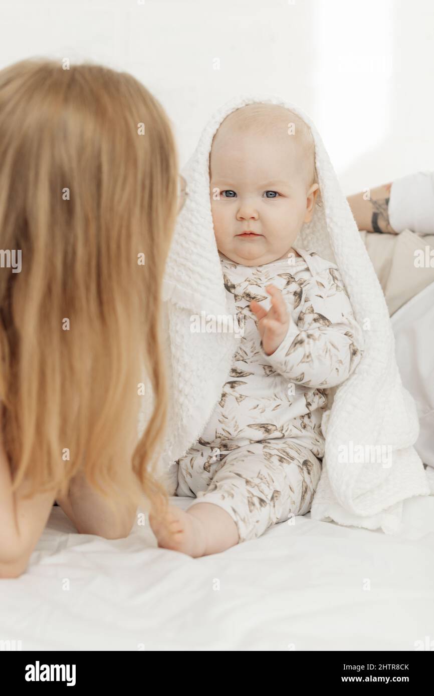Portrait of awesome blue-eyed plump baby infant covered with white ...