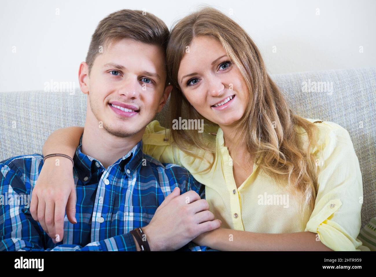 guy and pretty girl cuddling on sofa indoors Stock Photo - Alamy