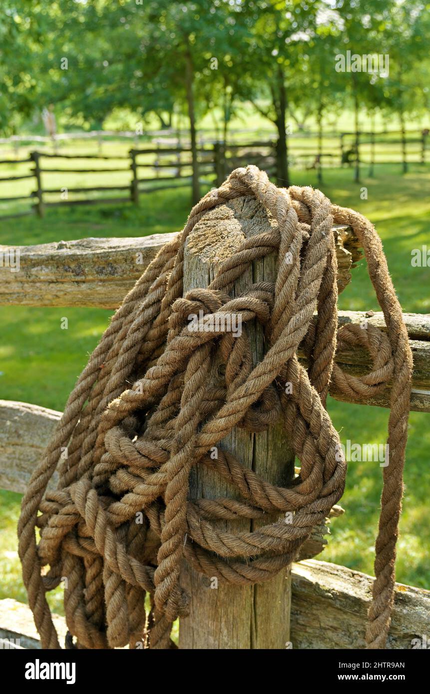 Thick Coiled Manila Rope Hanging over a Wooden Fencepost in a Rural ...