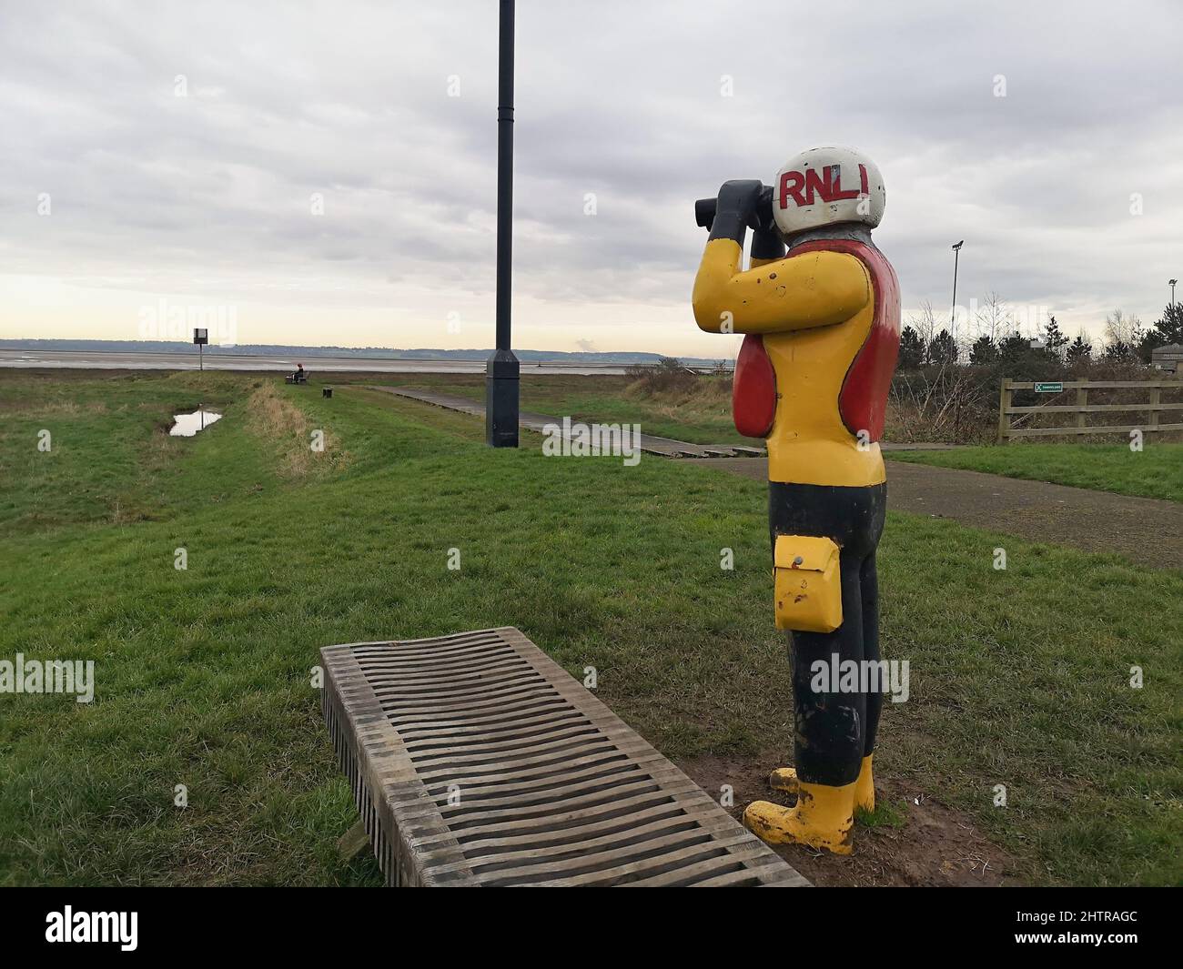 Wooden RNLI carved lookout statue looking through binocularsat ...