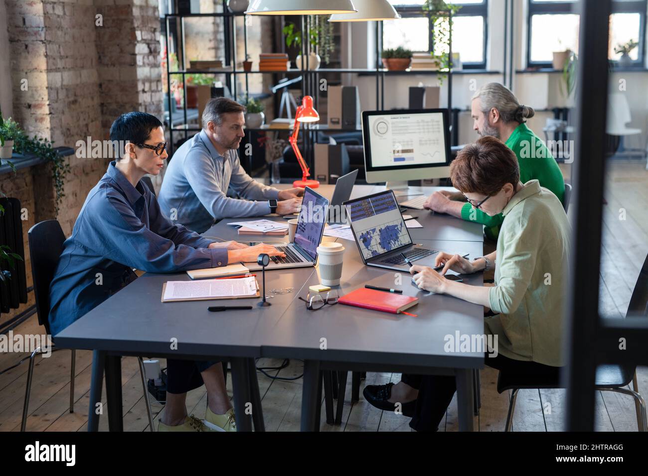 Group of business people sitting at the table and working with graphs ...
