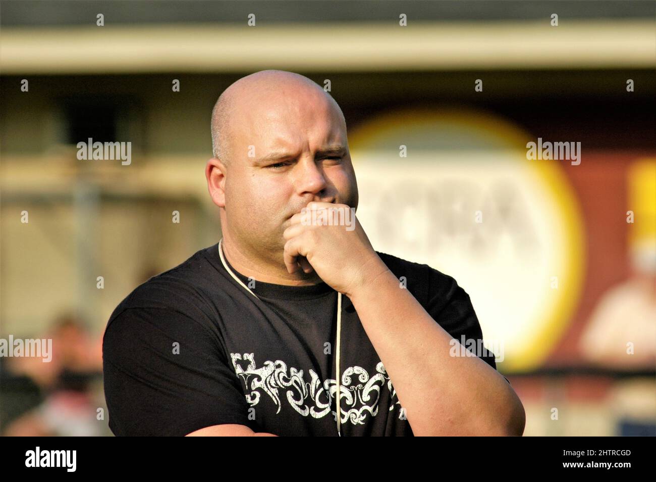 Shaved head football coach for little guys in full uniforms and pads ...