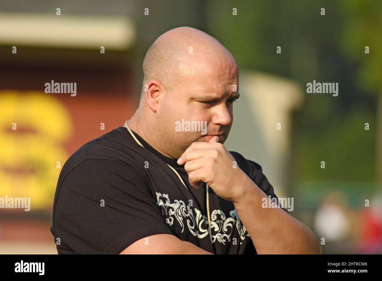 Shaved head football coach for little guys in full uniforms and pads ...