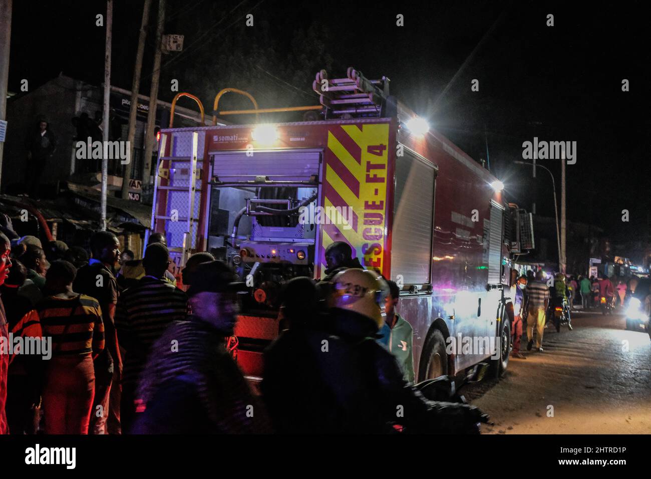Residents watch from a distance as firefighters struggle to put out a ...