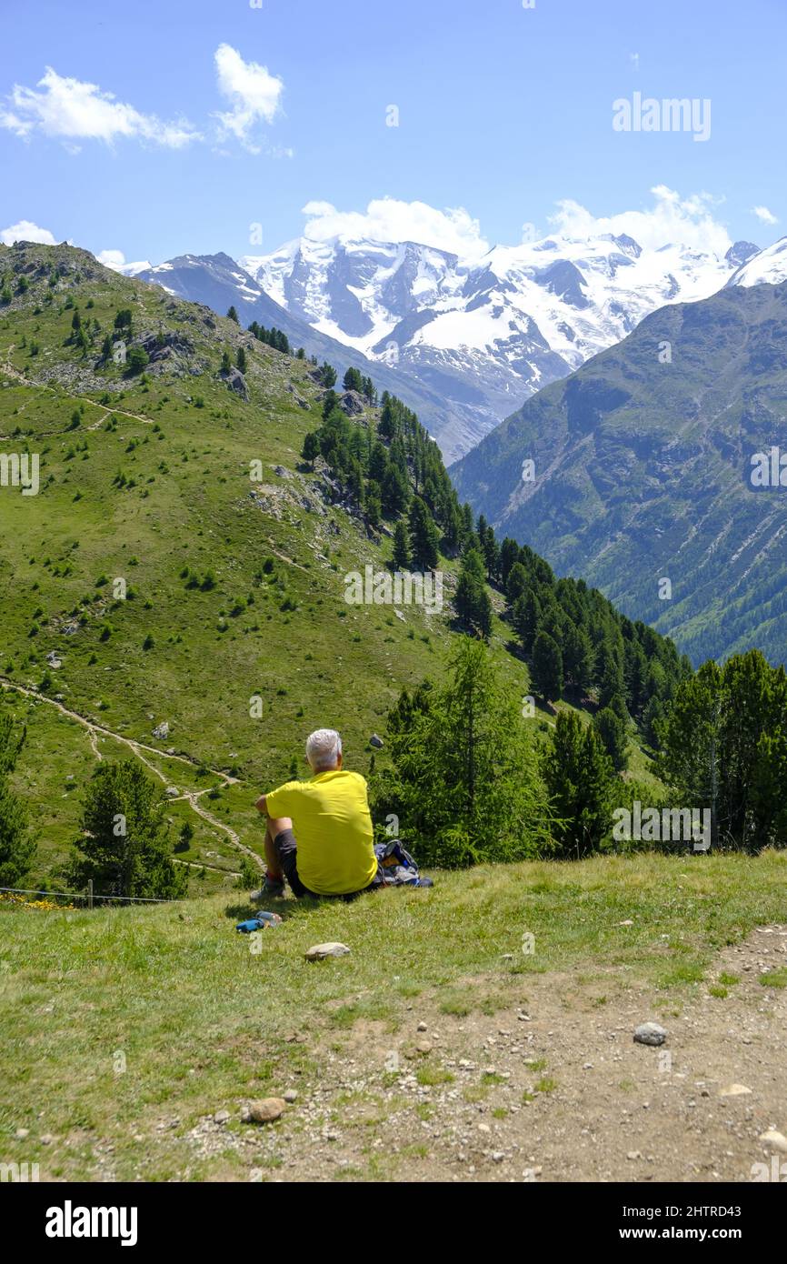 Vertical shot of a lonely person sitting on the grass and enjoying the ...