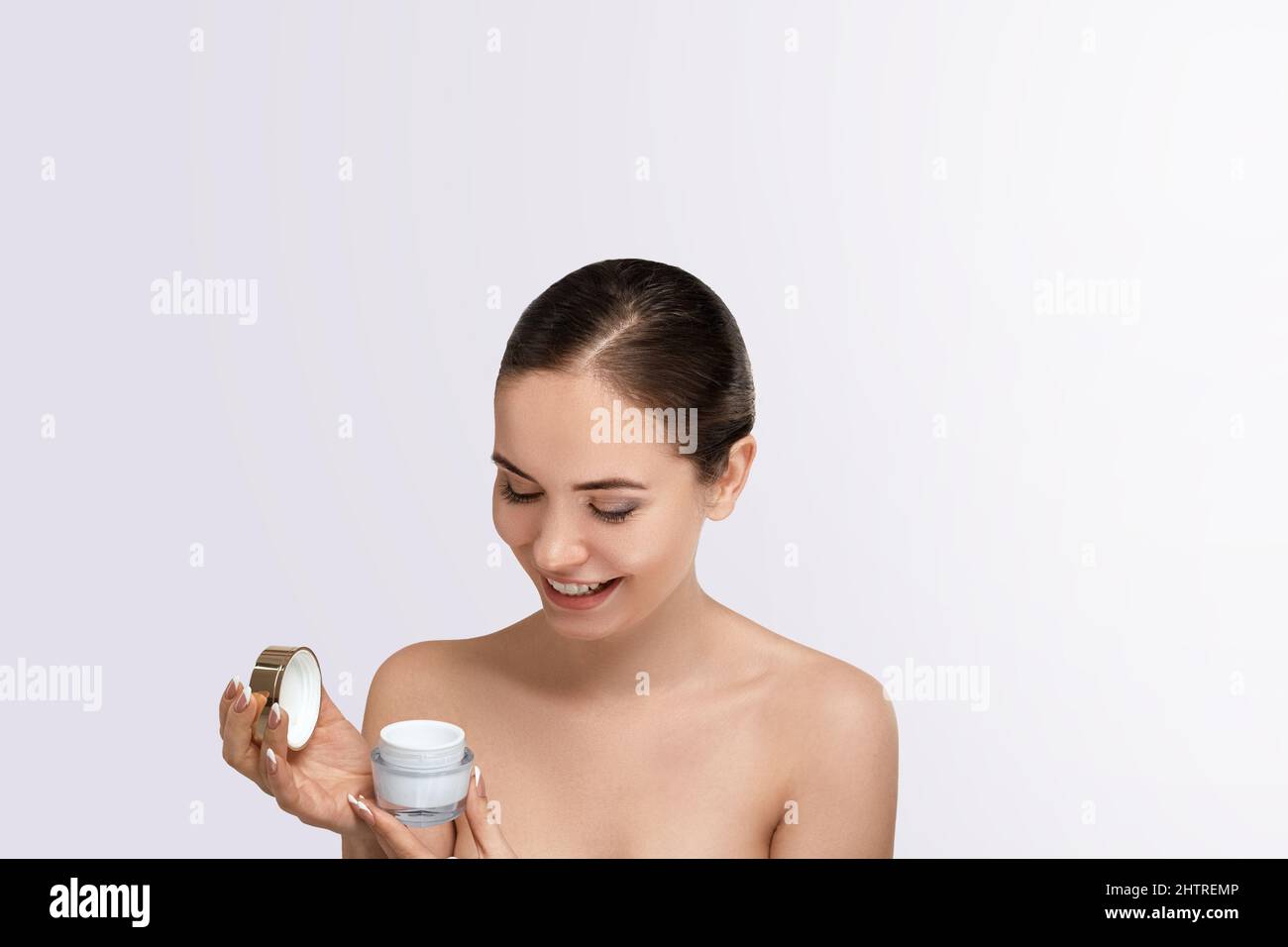 Beautiful Woman with healthy smooth facial clean skin holding bottle ...