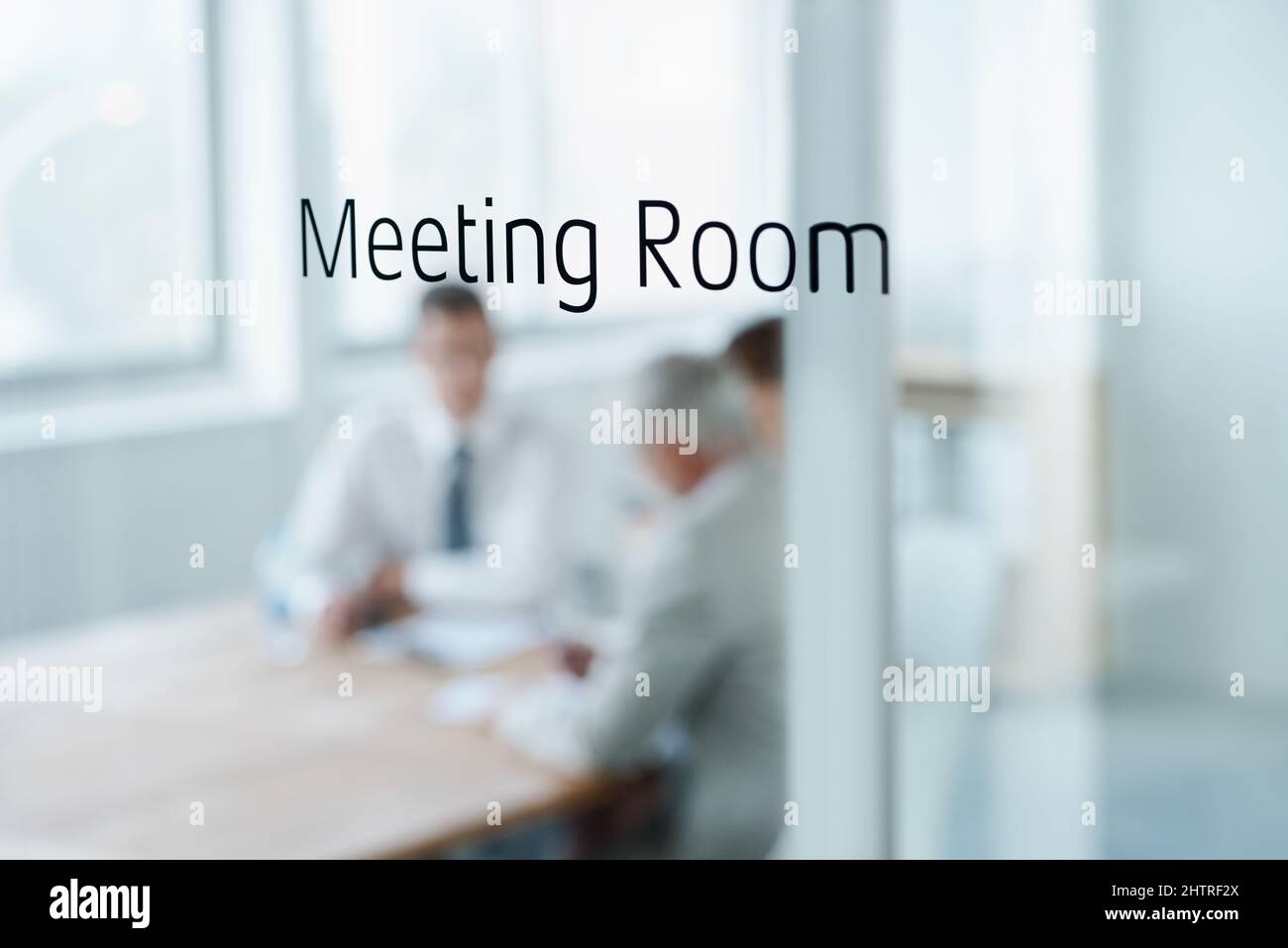 The meeting is in session. Closeup of a glass door reading meeting room ...
