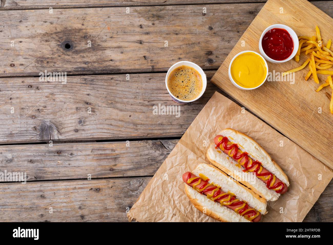Overhead view of hot dogs with french fries and sauces by drink on ...