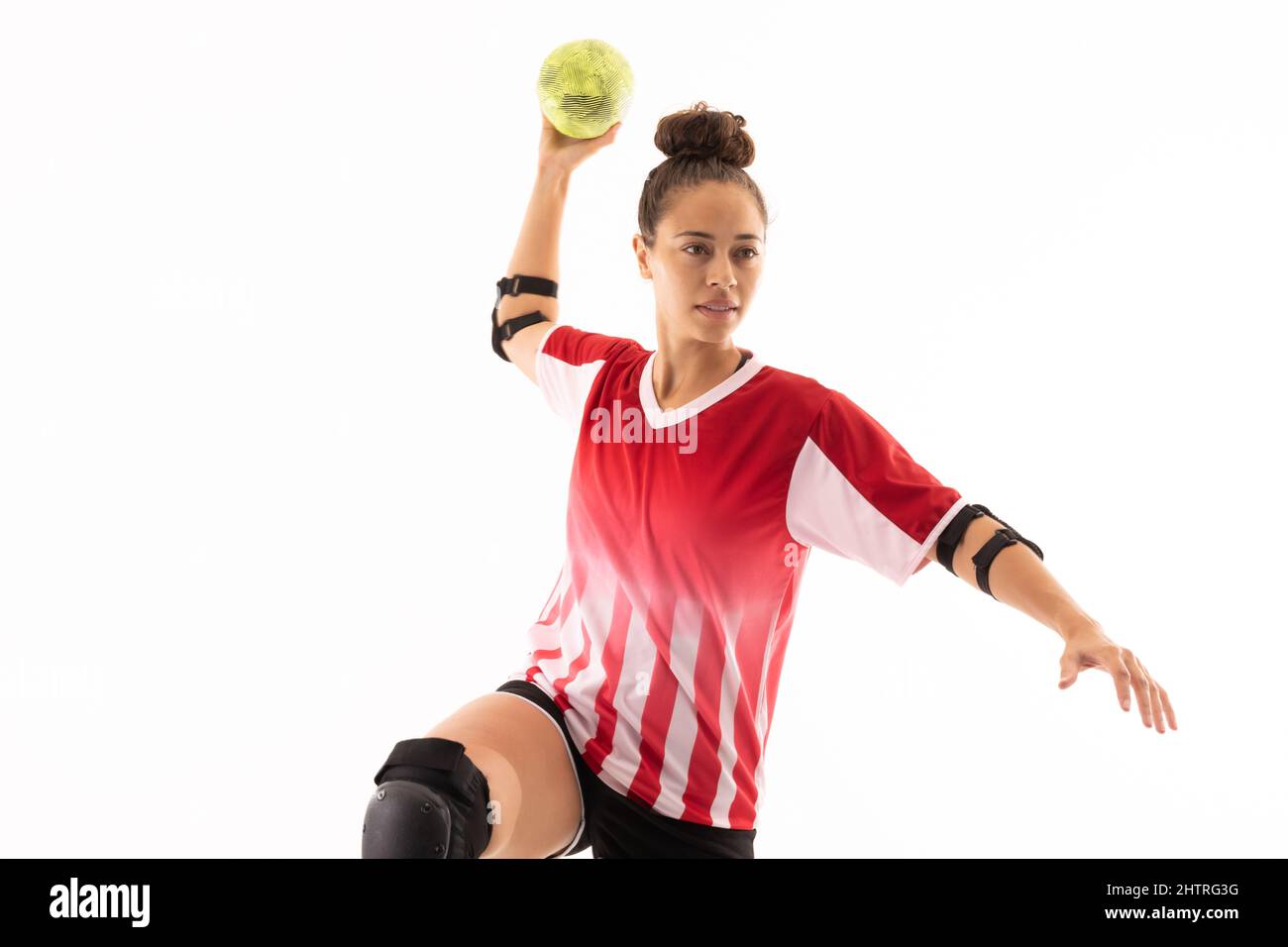 Biracial young female handball player throwing ball while playing ...