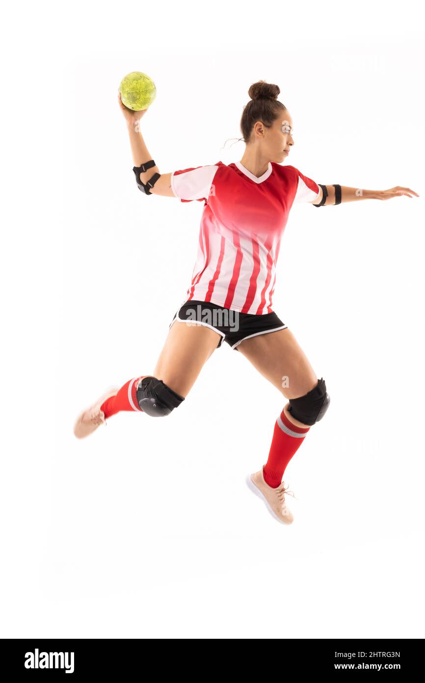 Full length of biracial young female handball player in mid-air playing ...