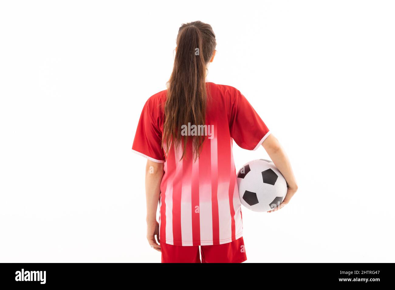 Rear view of caucasian young female soccer player with soccer ball ...