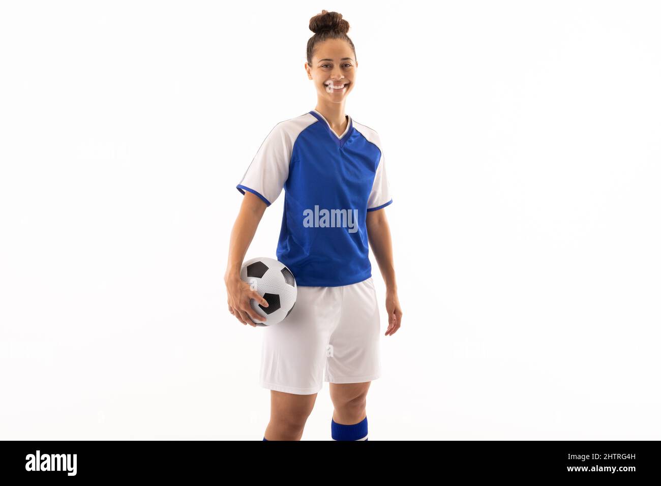 Portrait of smiling biracial young female soccer player with ball ...