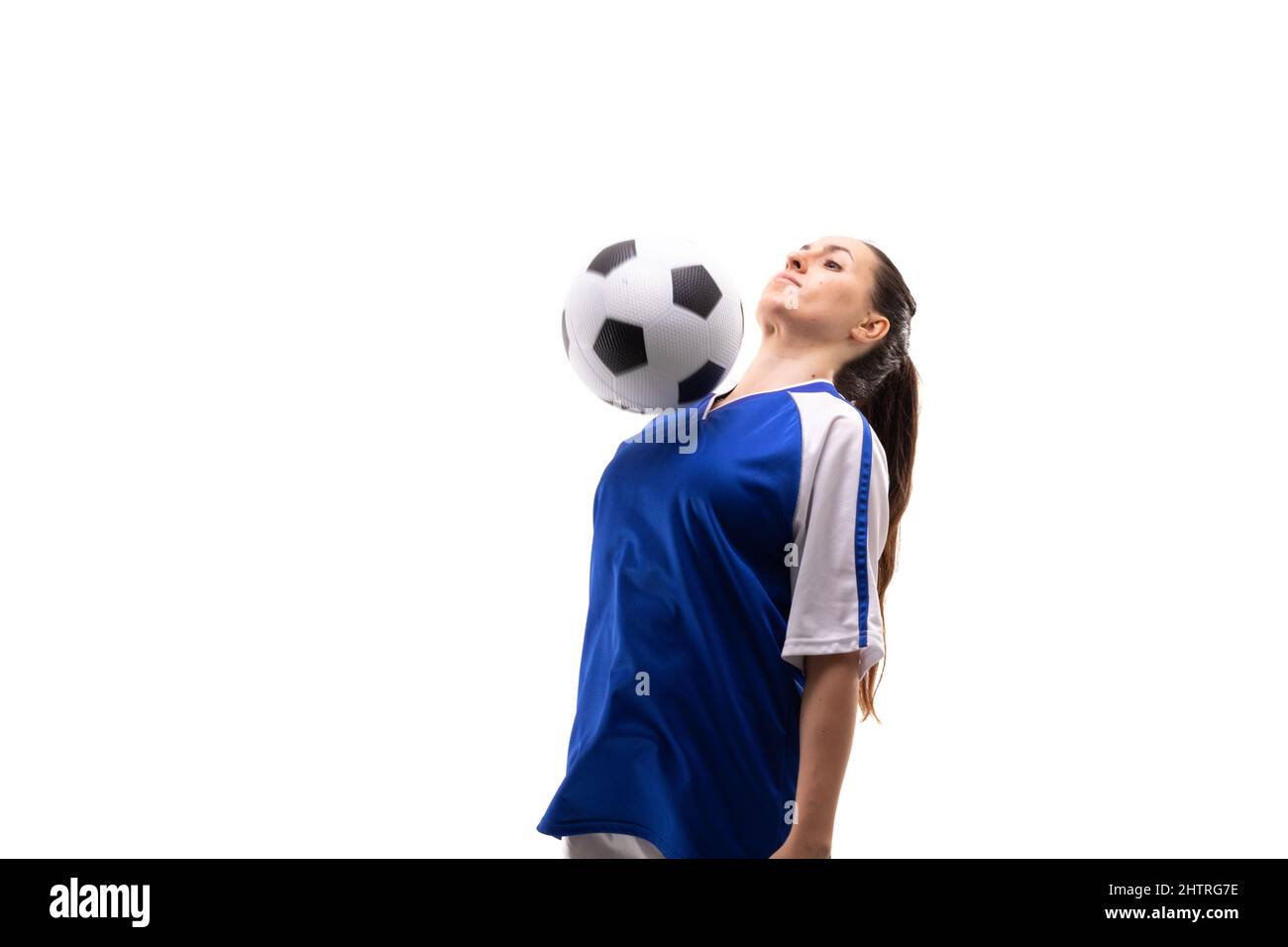 Caucasian young female soccer player hitting soccer ball with chest ...