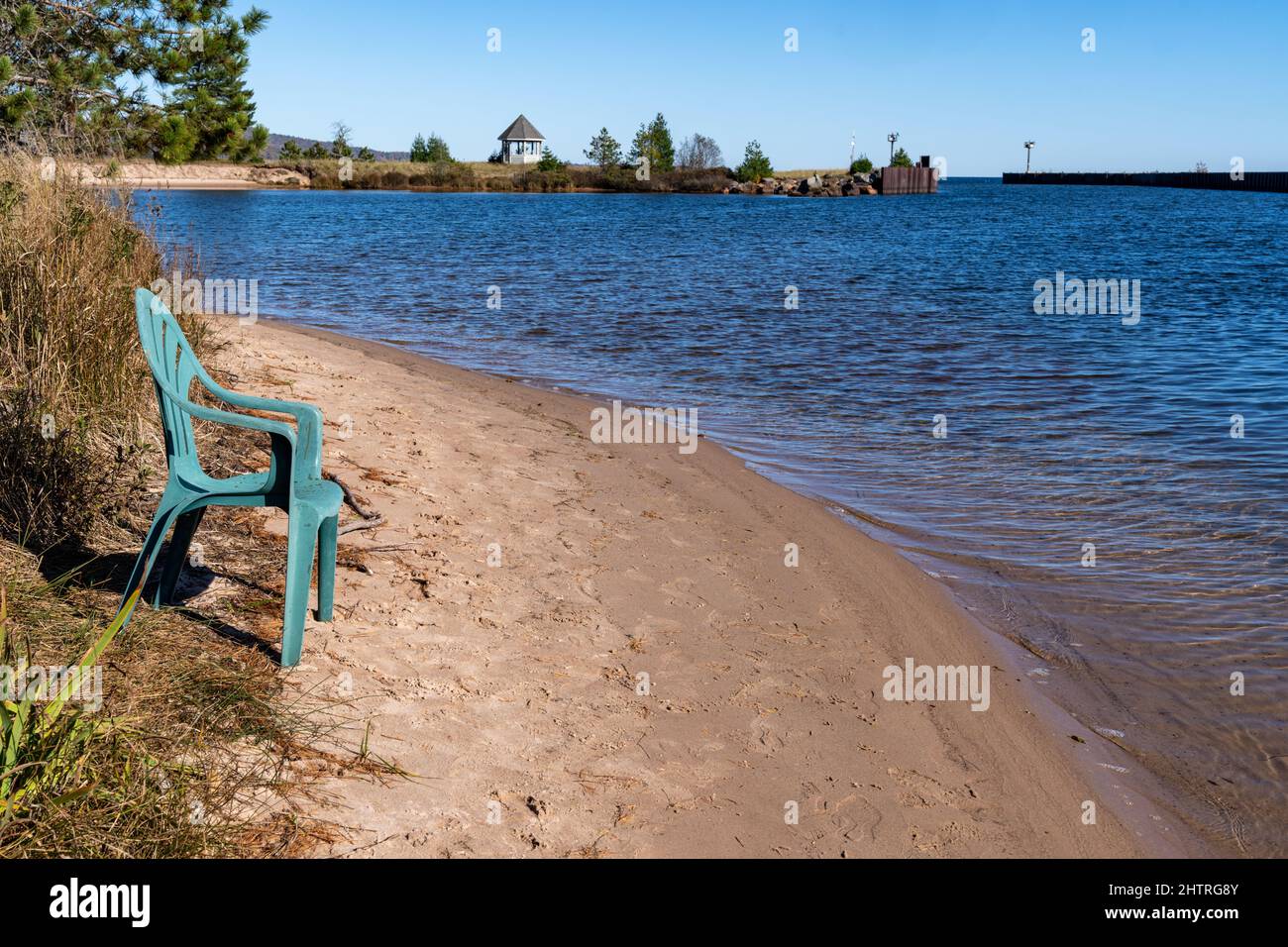 Green plastic lawn chair on the beach, near Bete Grise bay on Lake ...