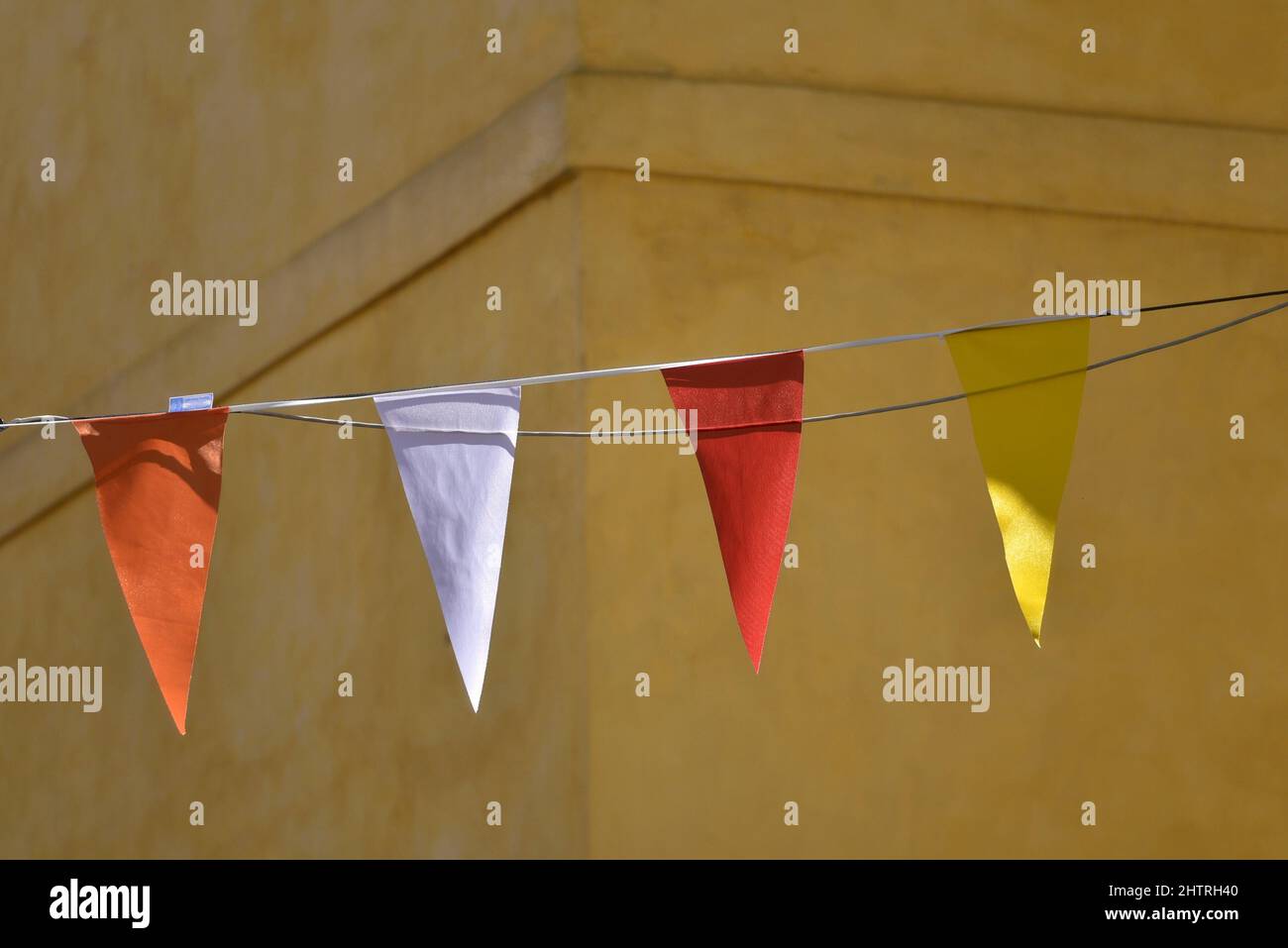 Colorful festive flags against an ochre stucco wall in Nafplio, Greece ...