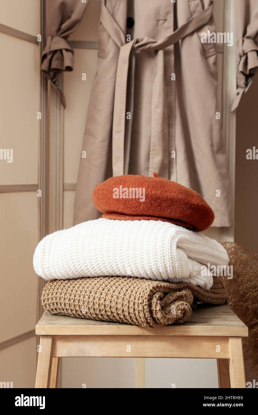 Step stool with stack of warm clothes in hall, closeup Stock Photo - Alamy