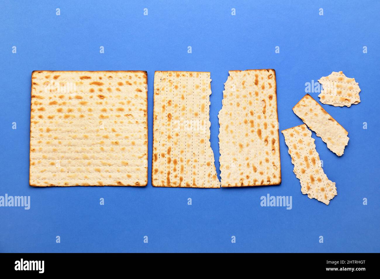 Torn Jewish flatbread matza for Passover on blue background Stock Photo ...
