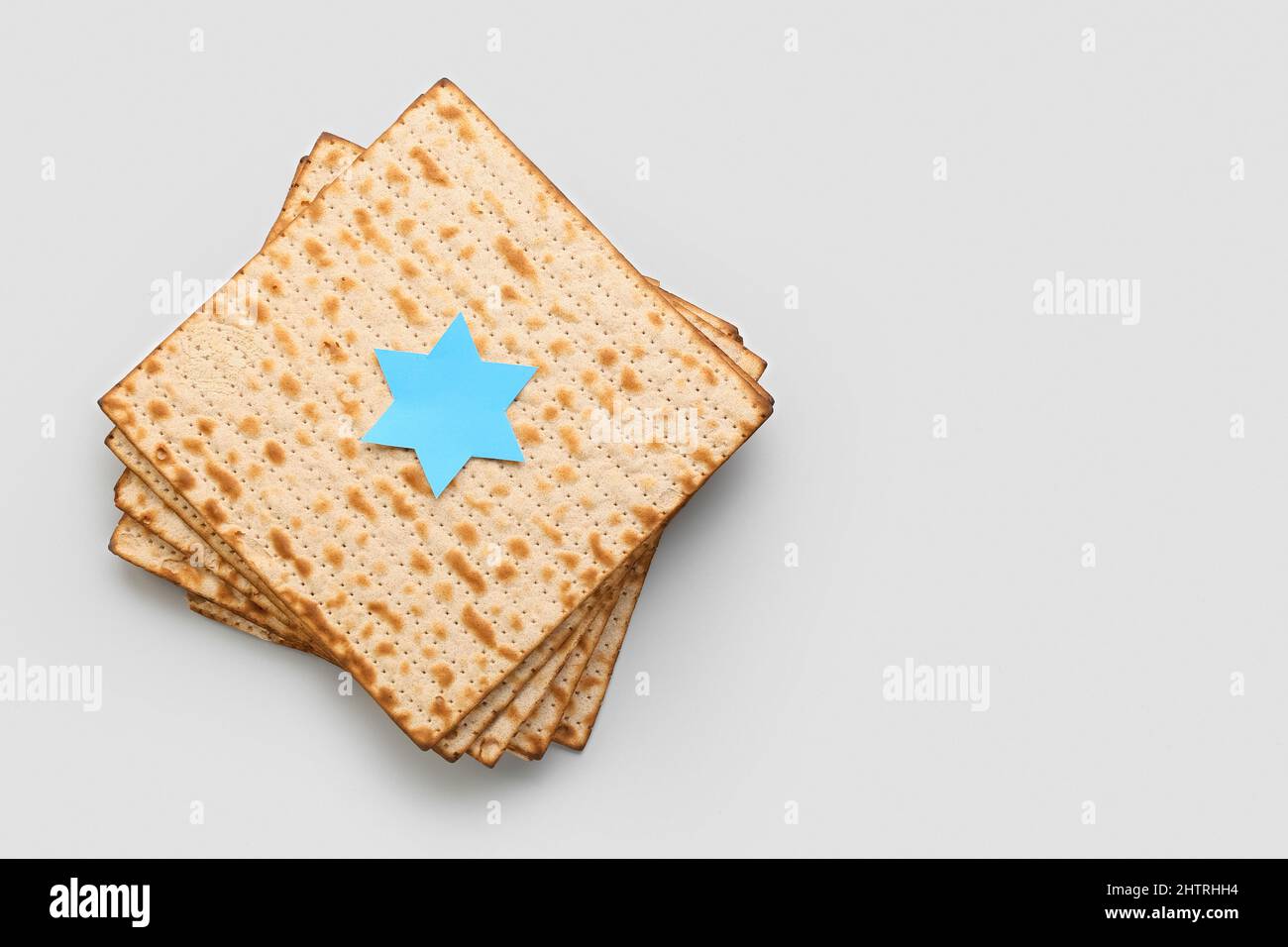 Jewish flatbread matza for Passover with paper David star on light ...
