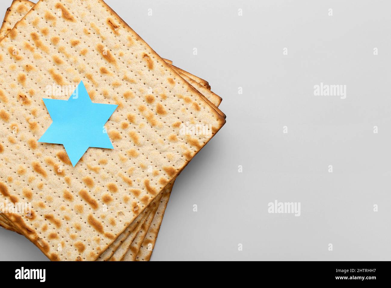 Jewish flatbread matza for Passover with paper David star on light ...