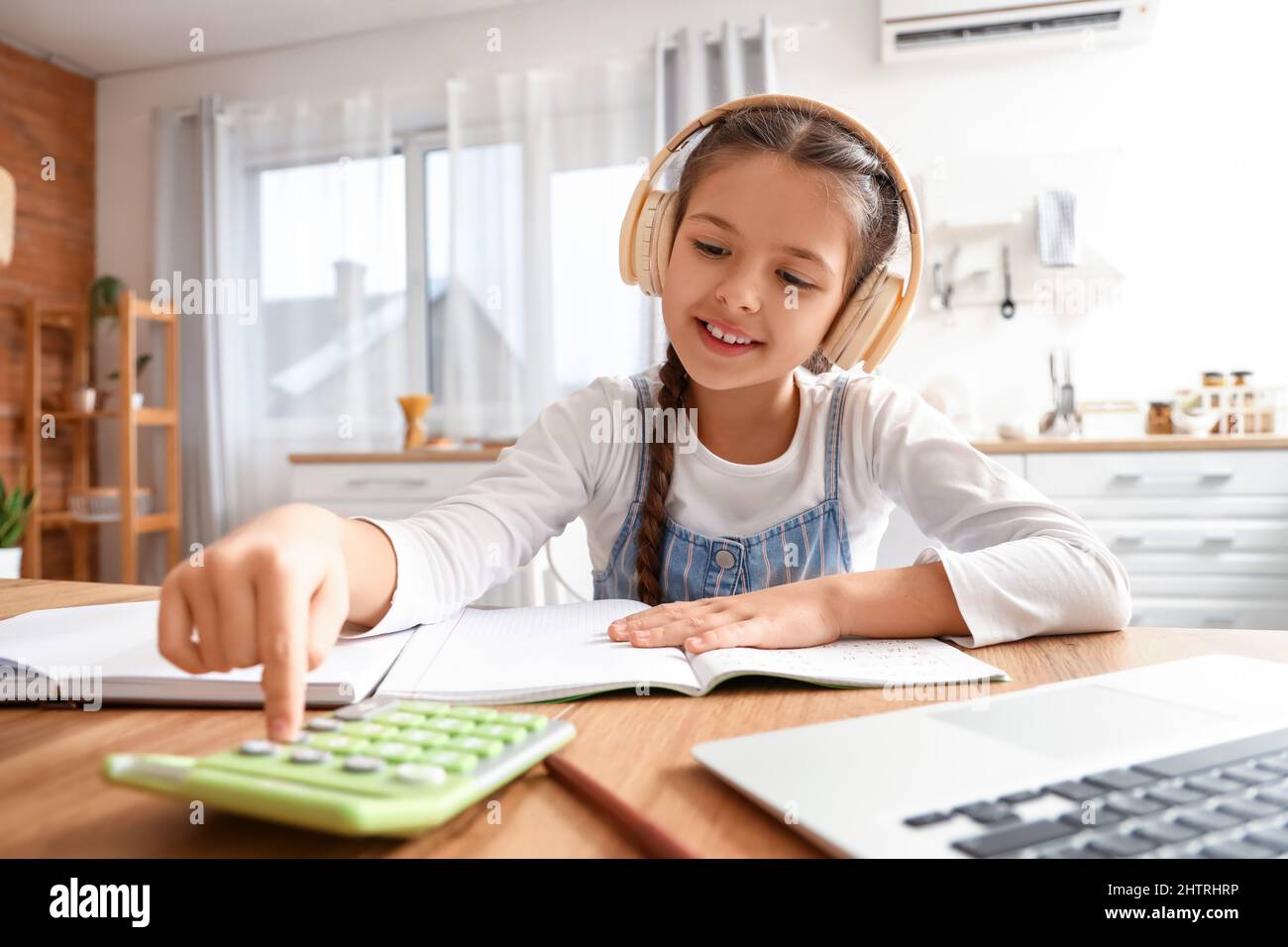 Little girl in headphones studying Math with online tutor at home Stock ...