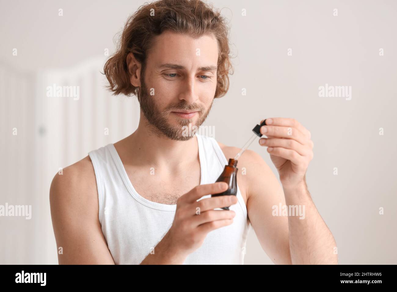 Young man using serum hi-res stock photography and images - Alamy