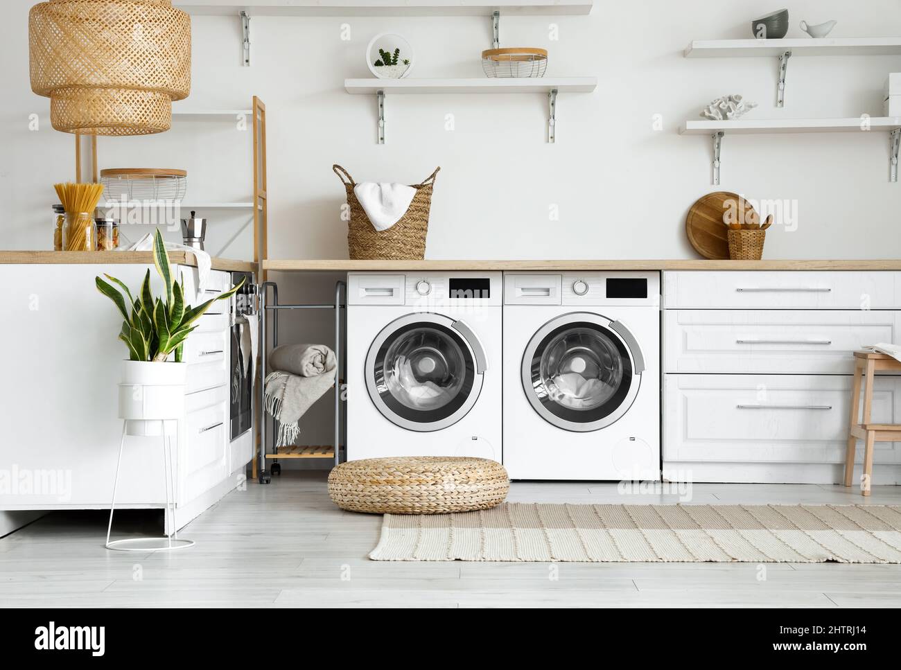 Interior of light kitchen with washing machines, laundry basket and ...
