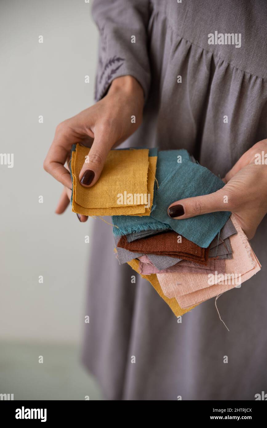 Woman wearing grey holding prices of colourful linen tissue examples ...