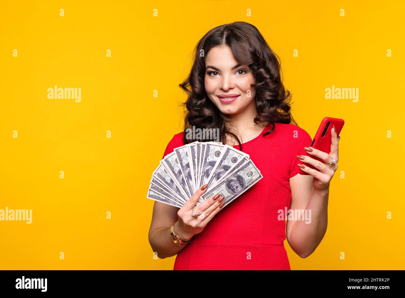 Business woman holds fan of cash dollars banknotes and smartphone in ...