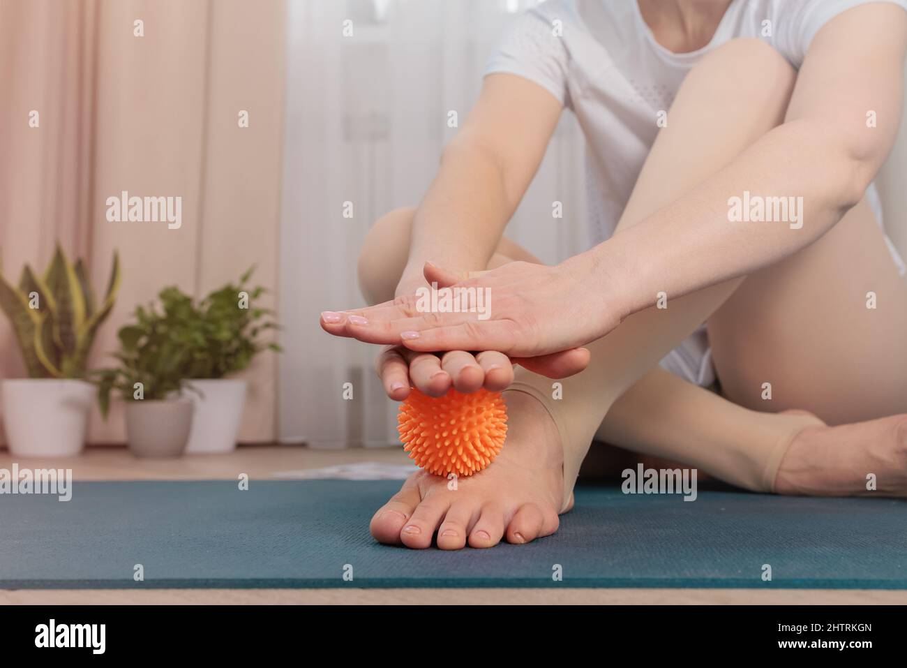 a girl massages her legs with a prickly ball to relax Stock Photo - Alamy