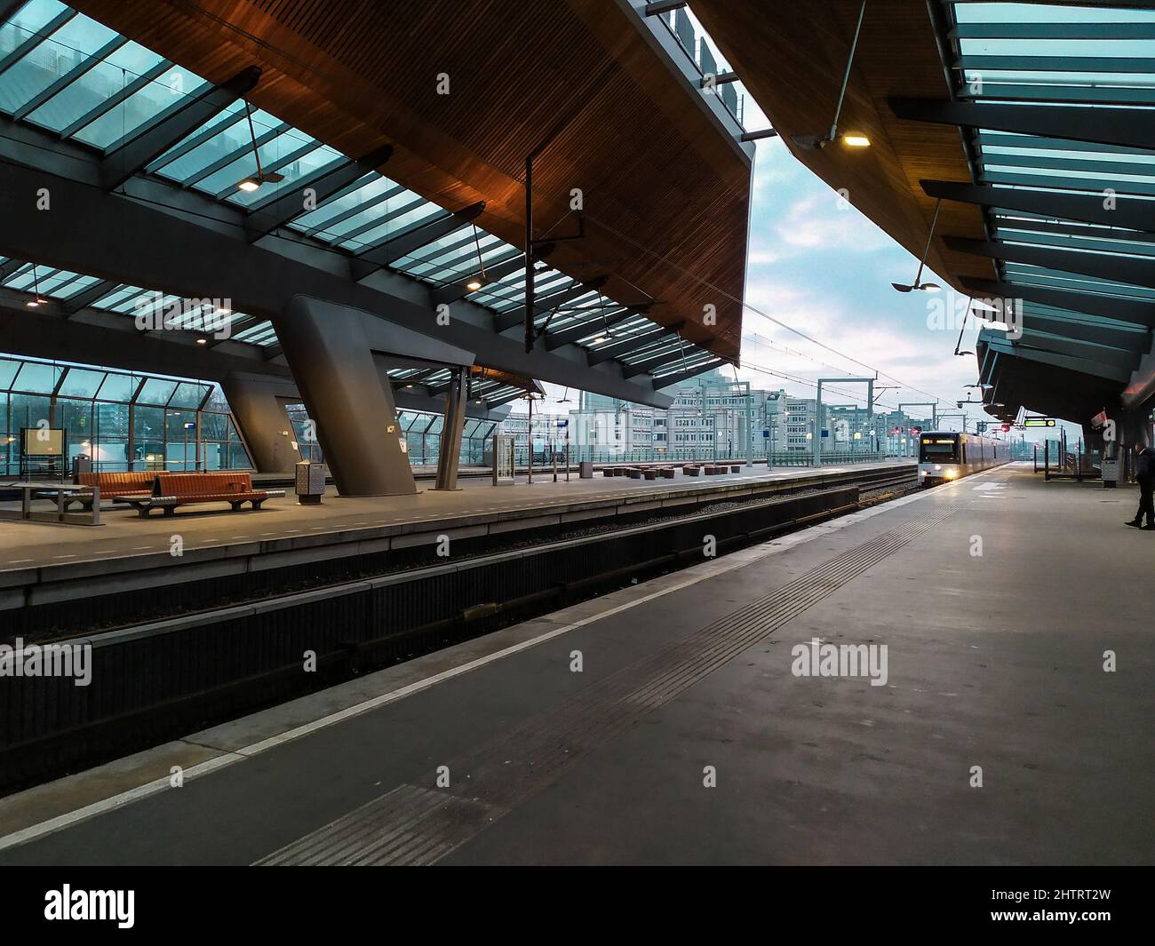 View of train arriving in train station building covered with glass ...