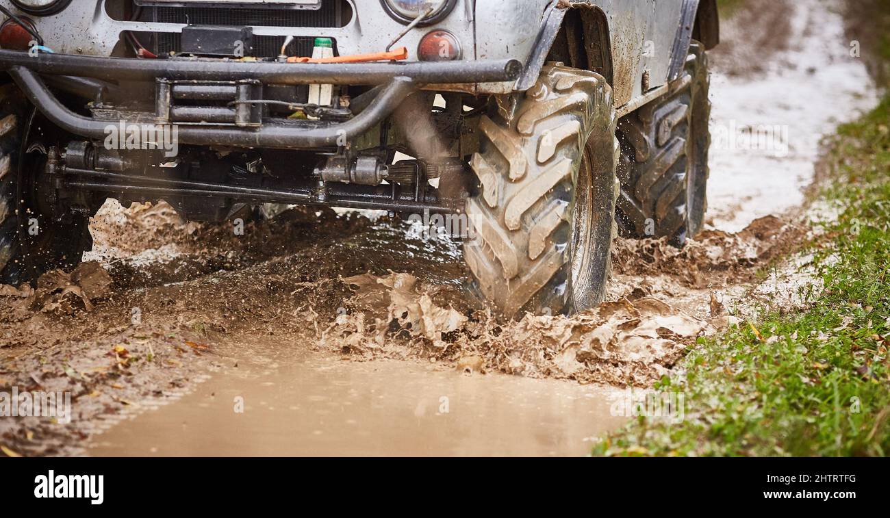 four - wheel drive truck is driving off-road. Close-up of the wheels ...