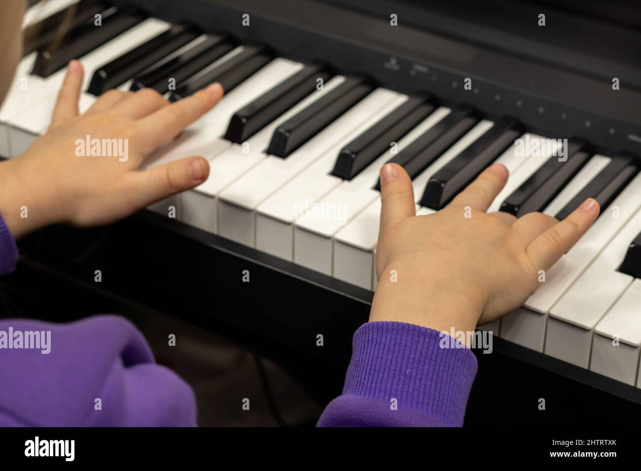 Selective focus on children's fingers and piano keys for playing the ...