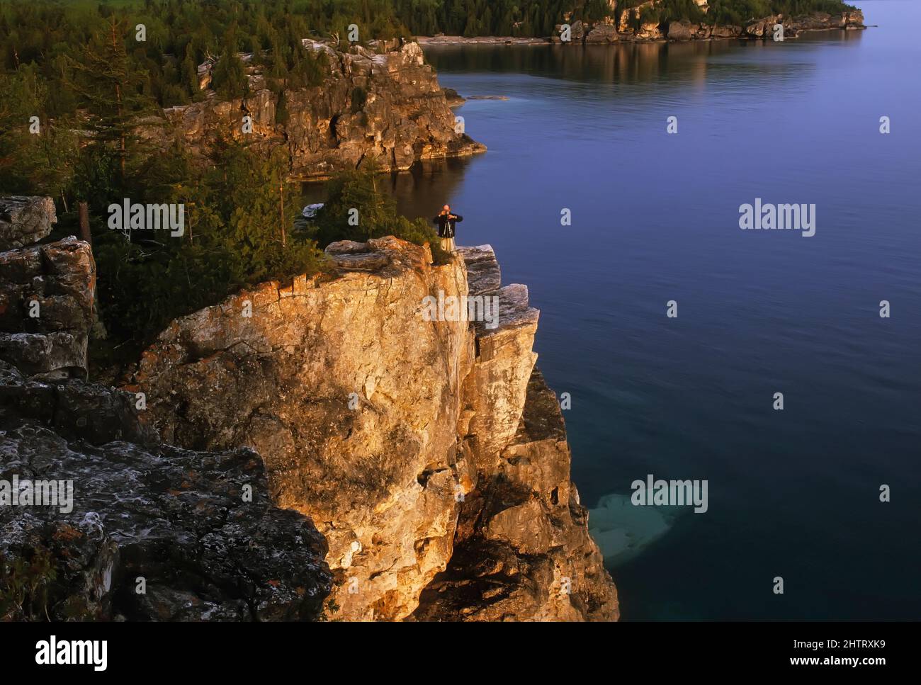 Photographer at Bruce Peninsula National Park Cliffs overlooking Lake ...