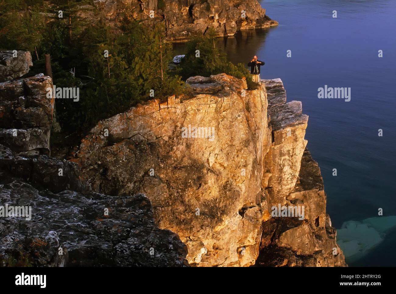 Photographer at Bruce Peninsula National Park Cliffs overlooking Lake ...