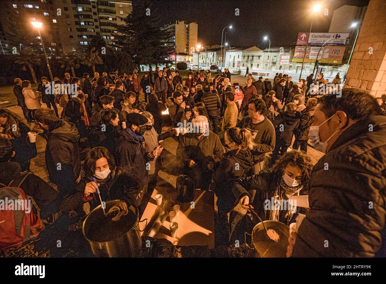 People line up to eat Castilian garlic soup during the traditional ...