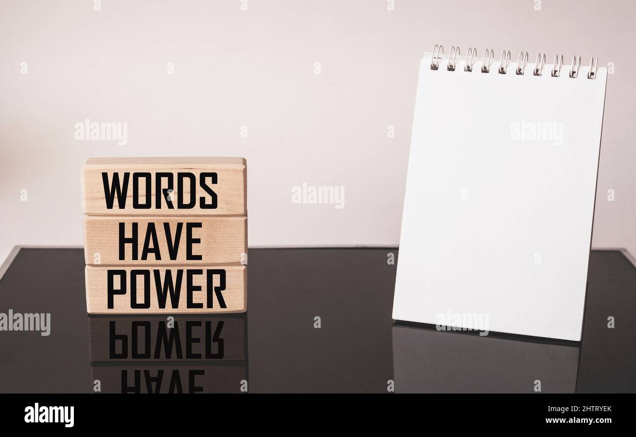 On wooden blocks the words Words Have Power on a black and white ...