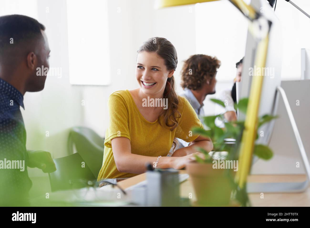 Sharing a work laugh. Shot of a team of designers talking while working ...