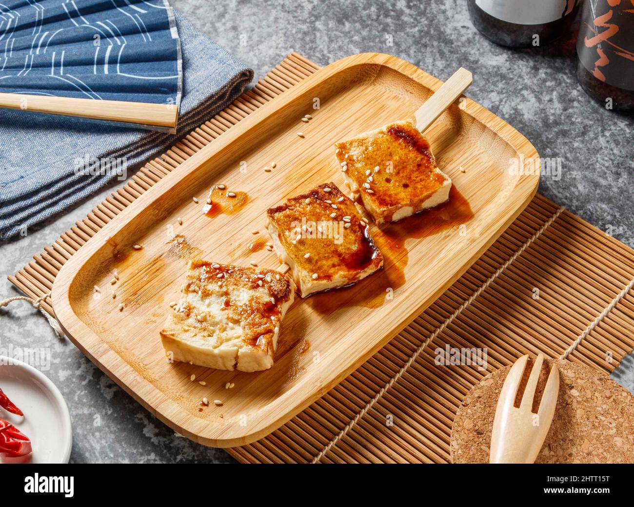 Hundred-page tofu skewers kebab sticks fried tofu cubes in wooden dish ...