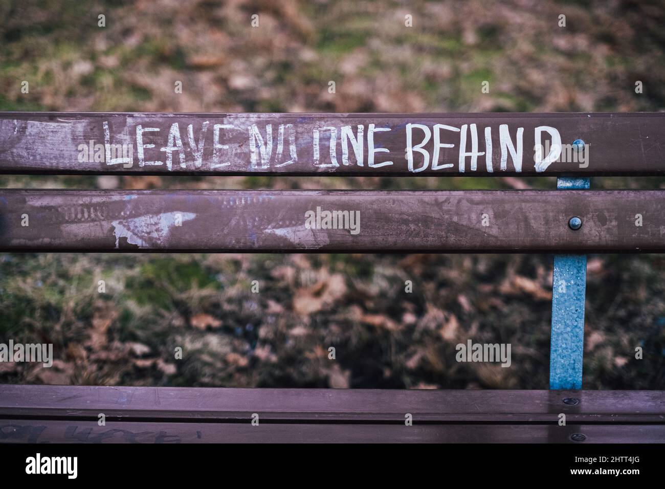 Closeup of the "Leave no one behind" text on a bench Stock Photo - Alamy