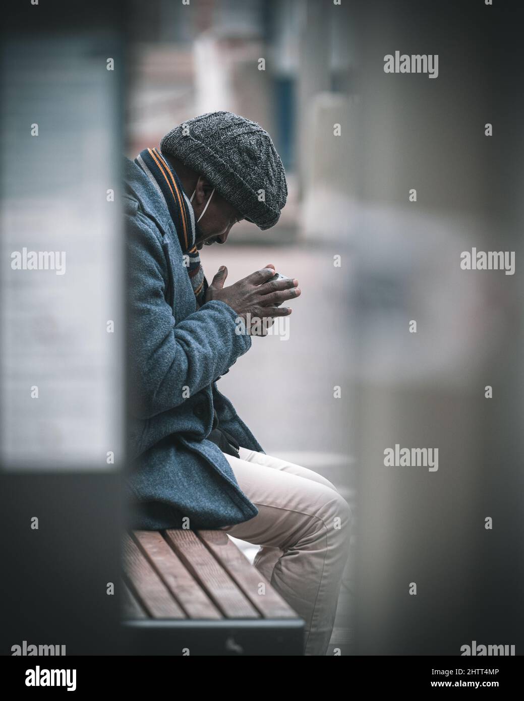 Closeup of a man sitting on the bench and praying Stock Photo - Alamy