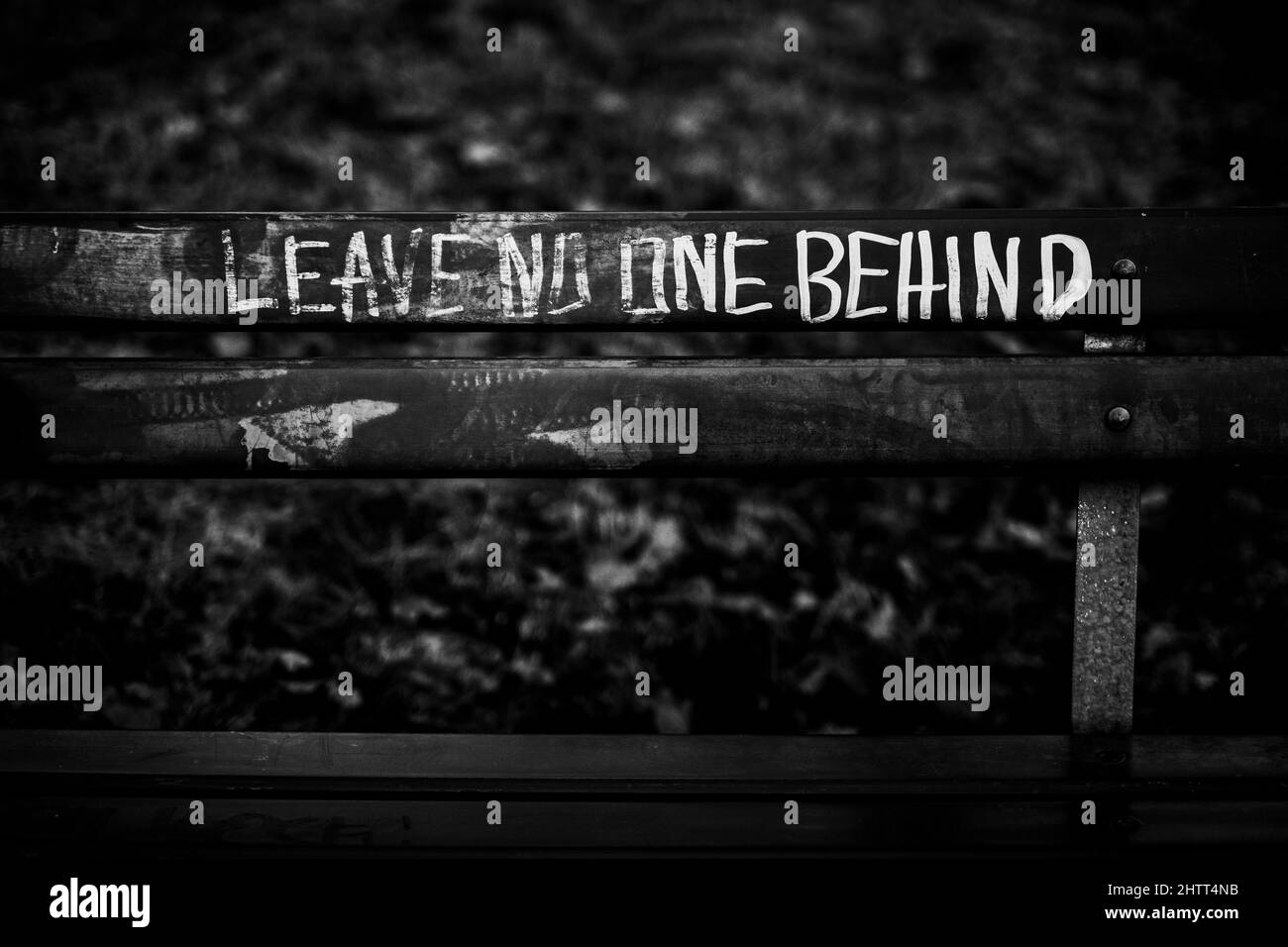 Closeup of the "Leave no one behind" text on a bench Stock Photo - Alamy