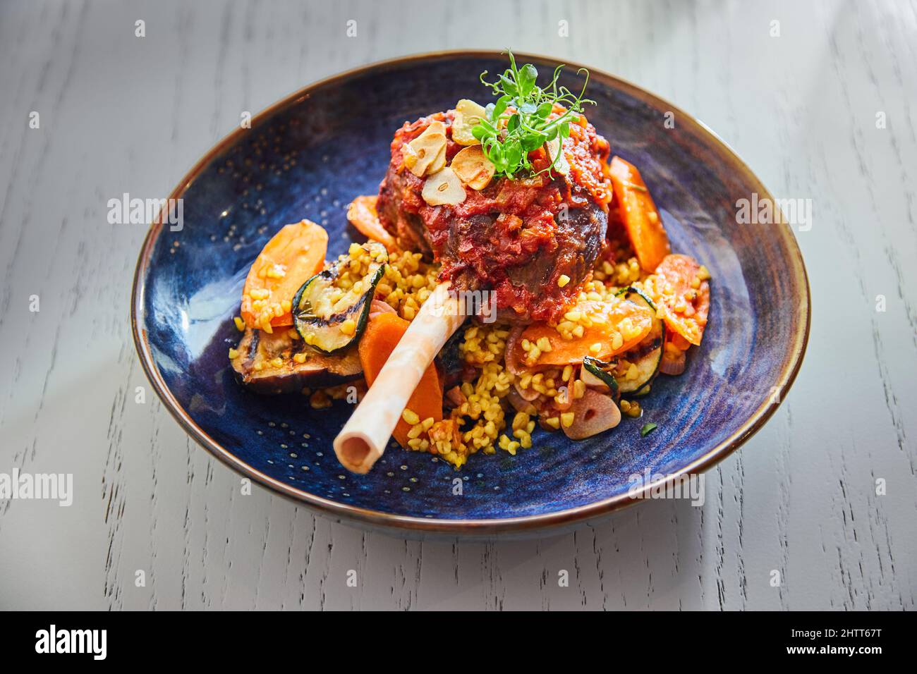 A top view of Lamb and mutton with vegetables on a ceramic blue plate ...