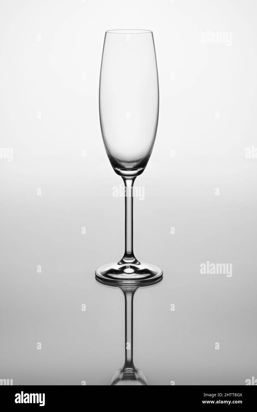 Vertical shot of a champagne glass with its reflection on a grey ...