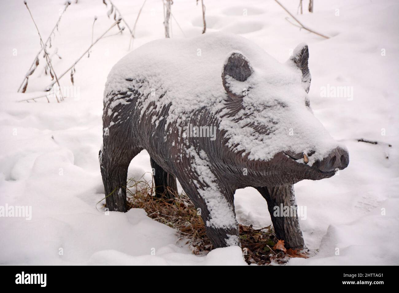 Wooden figurine of a crow covered with boar in the yard of a house ...