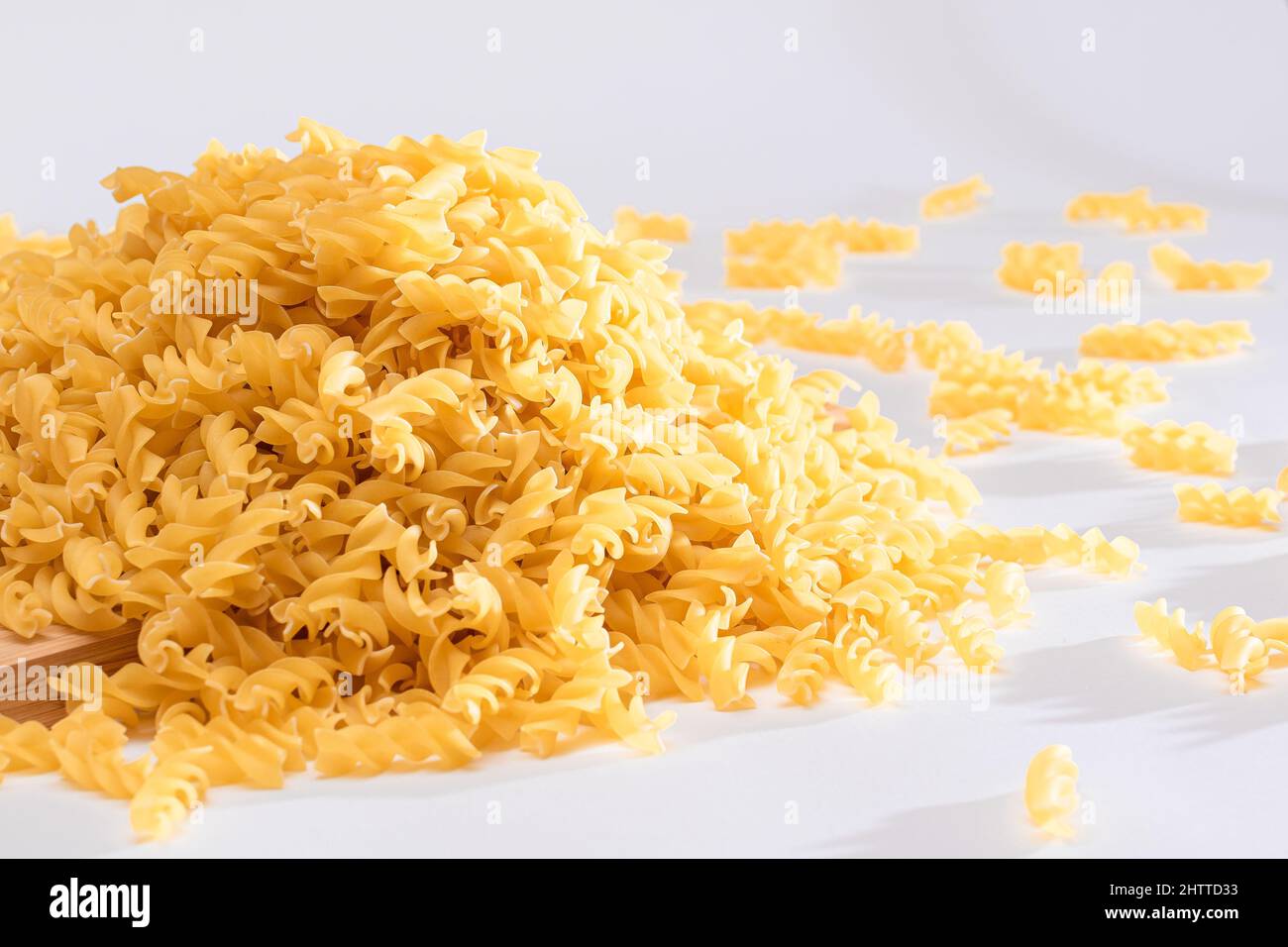Uncooked Fusilli Pasta Scattered on Wooden Board and White Table. Raw ...